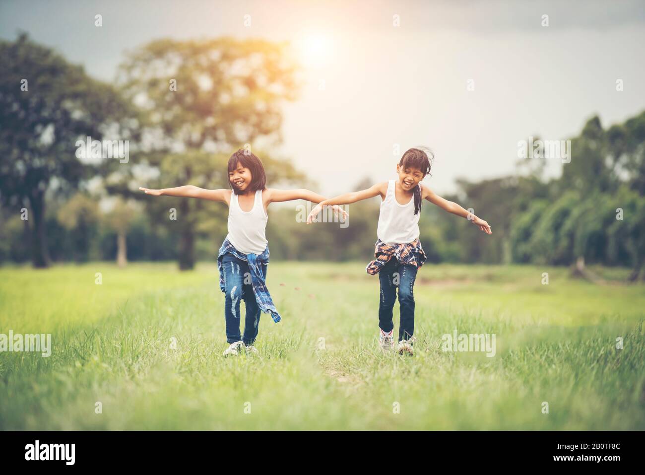 Two little cute girls are running on green grass. Best friends Stock ...