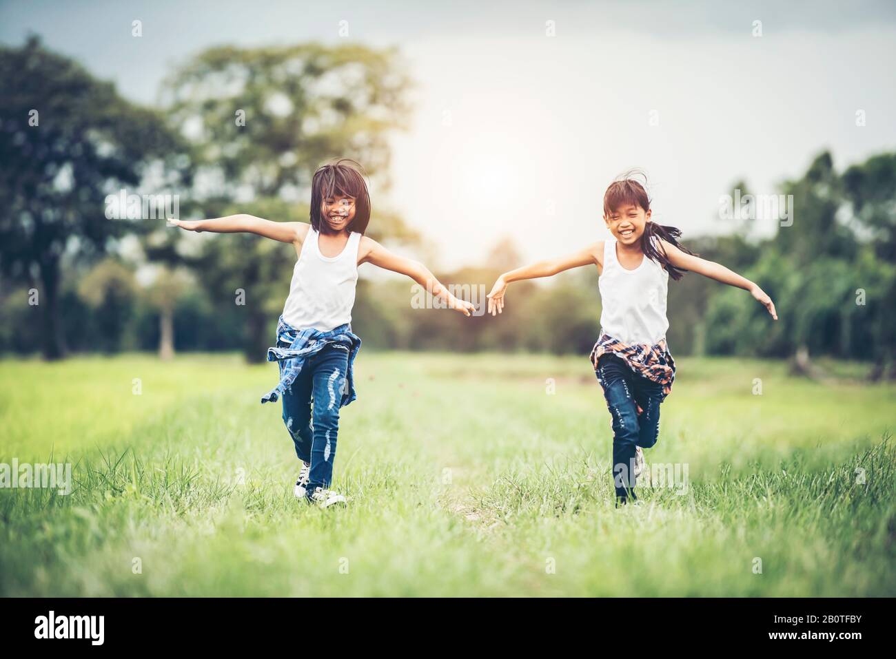 Two little cute girls are running on green grass. Best friends Stock ...