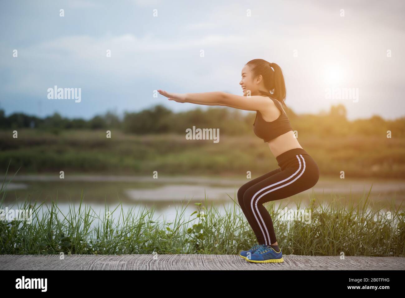 Healthy young woman warming up outdoors workout before training session ...