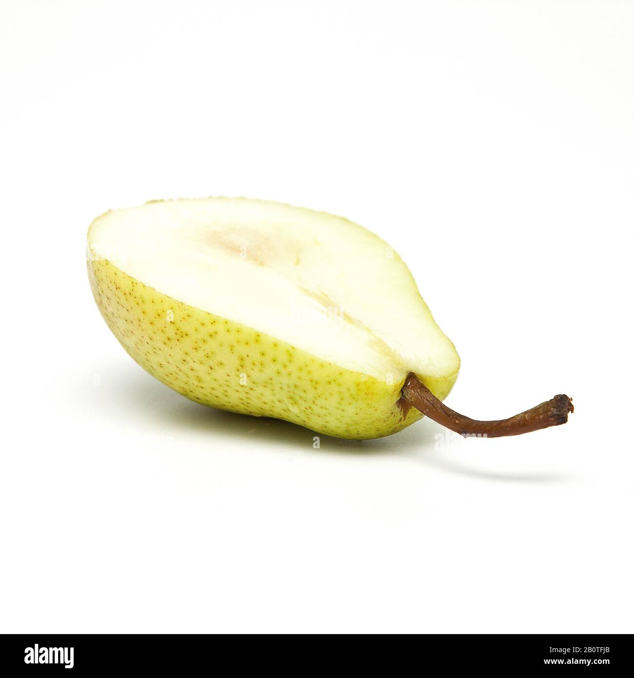Single pear cut in half on a white background Stock Photo - Alamy
