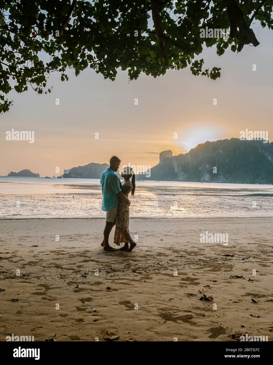 couple on the beach during sunset at the tropical Krabi area Thailand ...