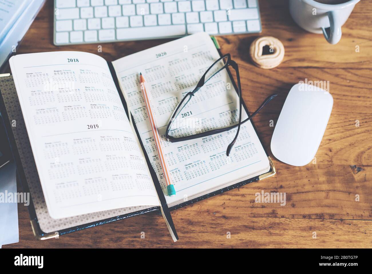 open calendar in a notebook on a desktop in front of a computer Stock ...