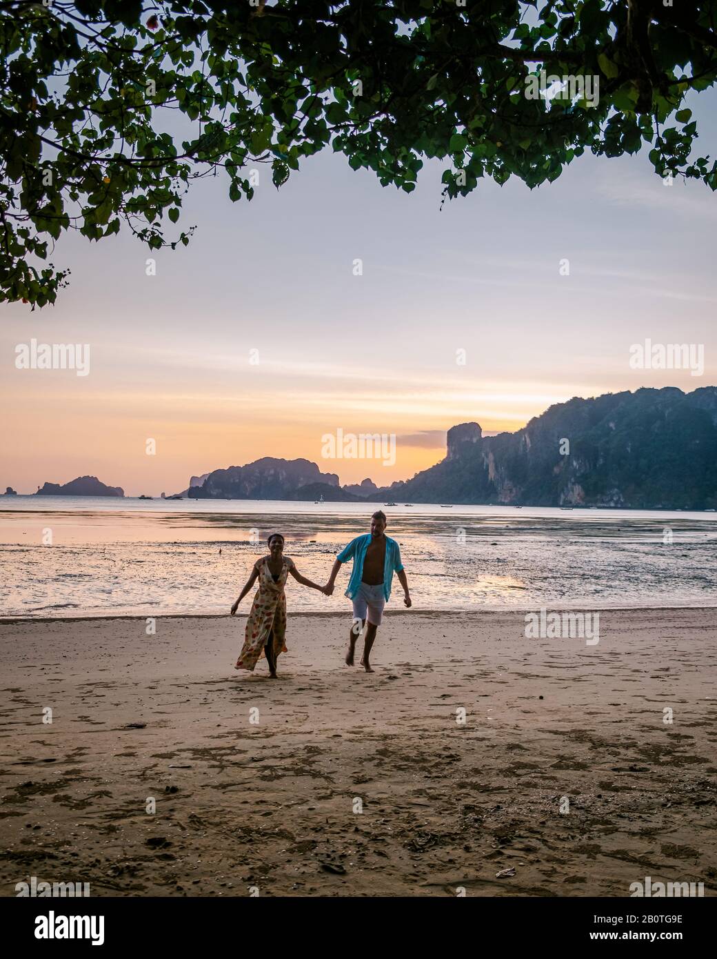 couple on the beach during sunset at the tropical Krabi area Thailand ...