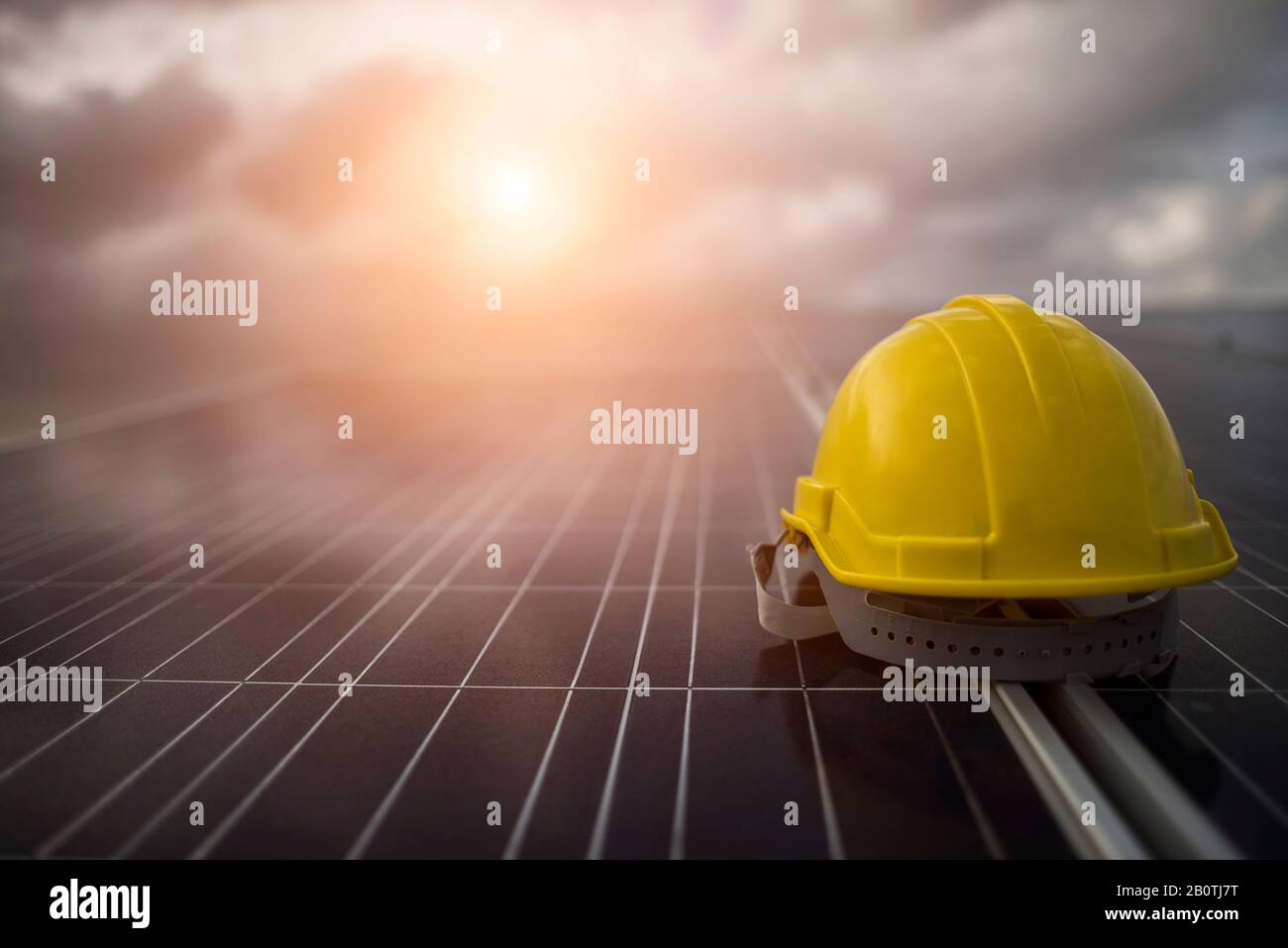 Yellow safety helmet on solar cell panel Stock Photo - Alamy