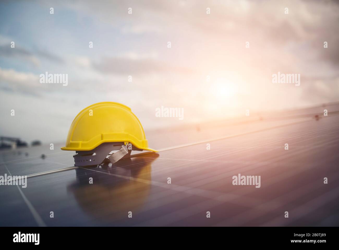 Yellow safety helmet on solar cell panel Stock Photo - Alamy