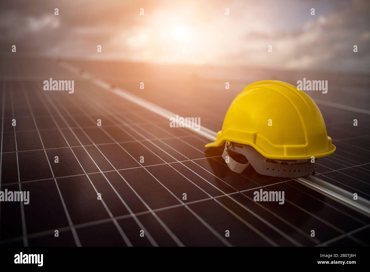 Yellow safety helmet on solar cell panel Stock Photo - Alamy