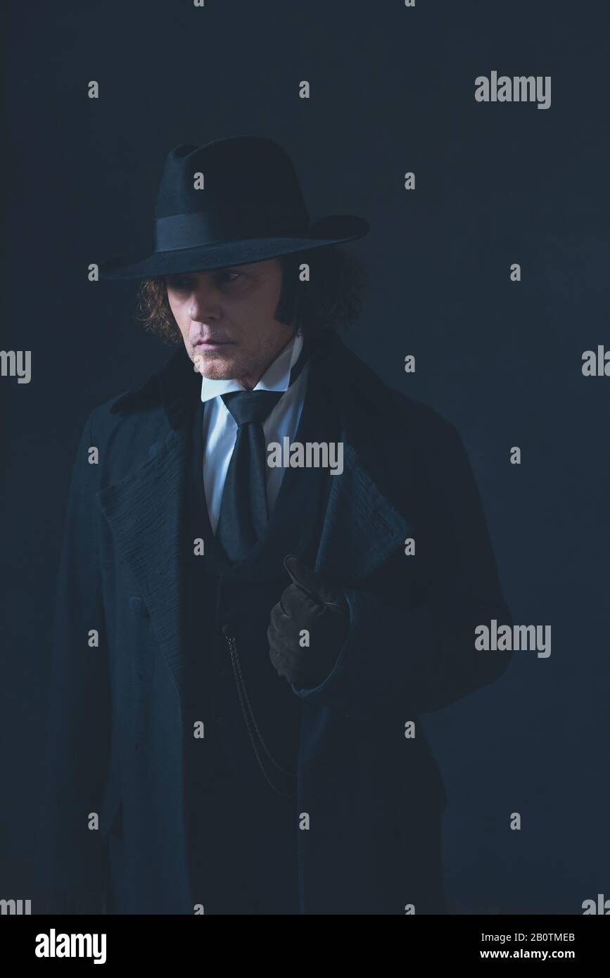 Mysterious victorian man in black coat and hat Stock Photo - Alamy