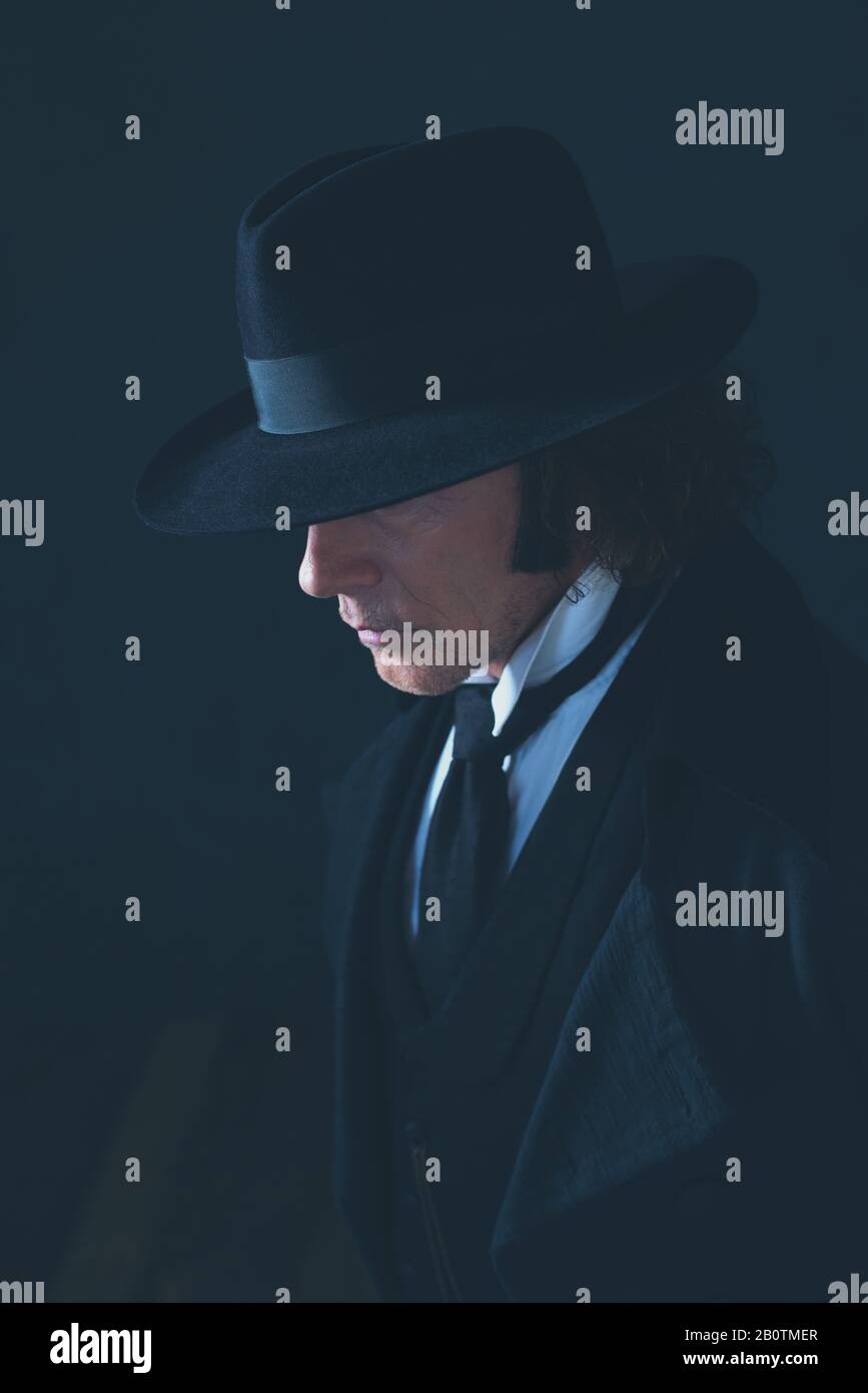 Mysterious victorian man in black coat and hat Stock Photo - Alamy