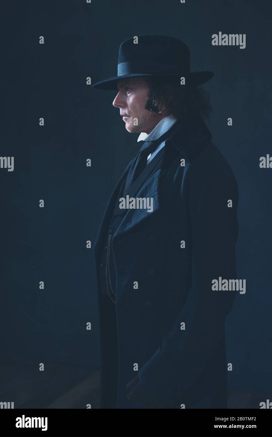 Mysterious victorian man in black coat and hat Stock Photo - Alamy