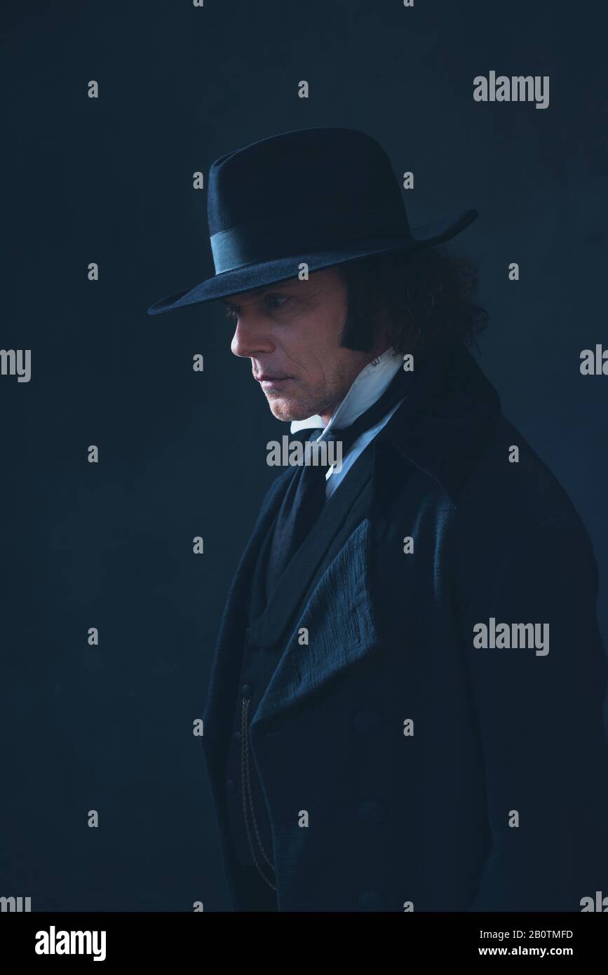 Mysterious victorian man in black coat and hat Stock Photo - Alamy