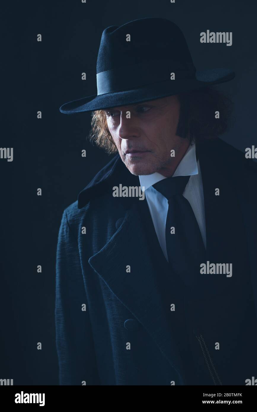 Mysterious victorian man in black coat and hat Stock Photo - Alamy