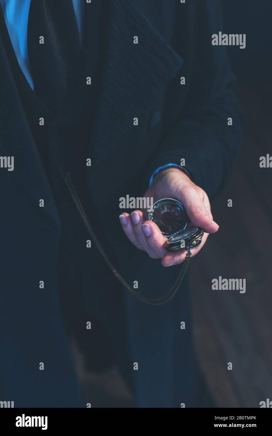 Edwardian man in long black coat holding pocket watch Stock Photo - Alamy