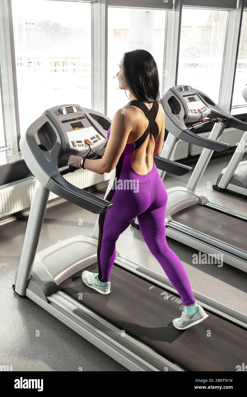 Running. Young muscular caucasian woman practicing in gym with cardio ...