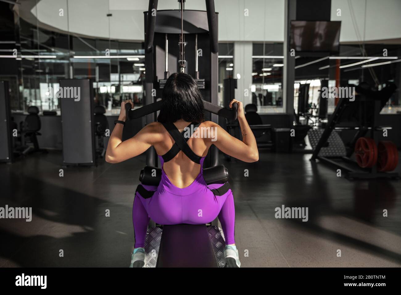 High. Young muscular caucasian woman practicing in gym with equipment ...
