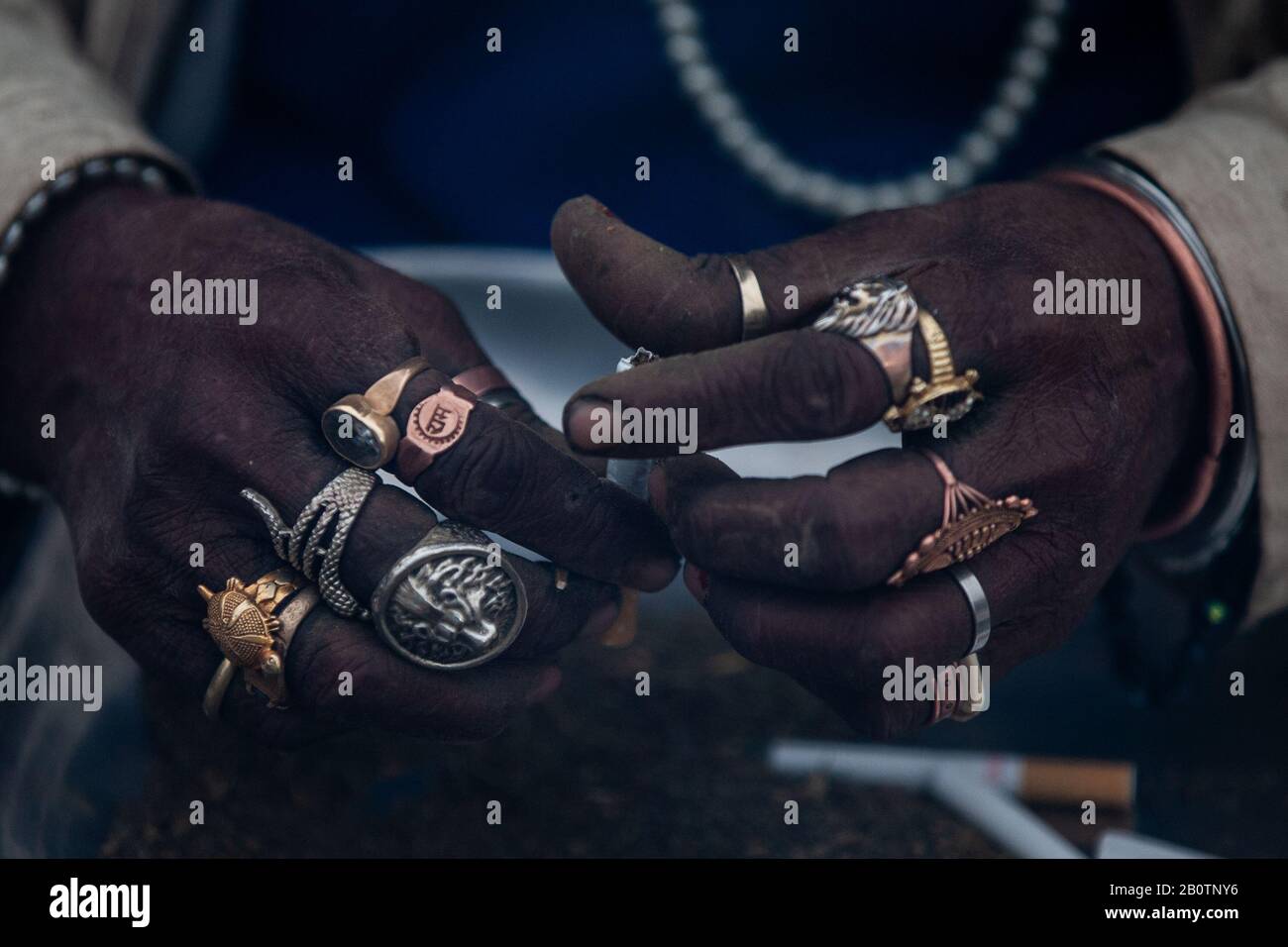 Hands of a Sadhu (holy man) prepare marijuana in a chillum (traditional ...
