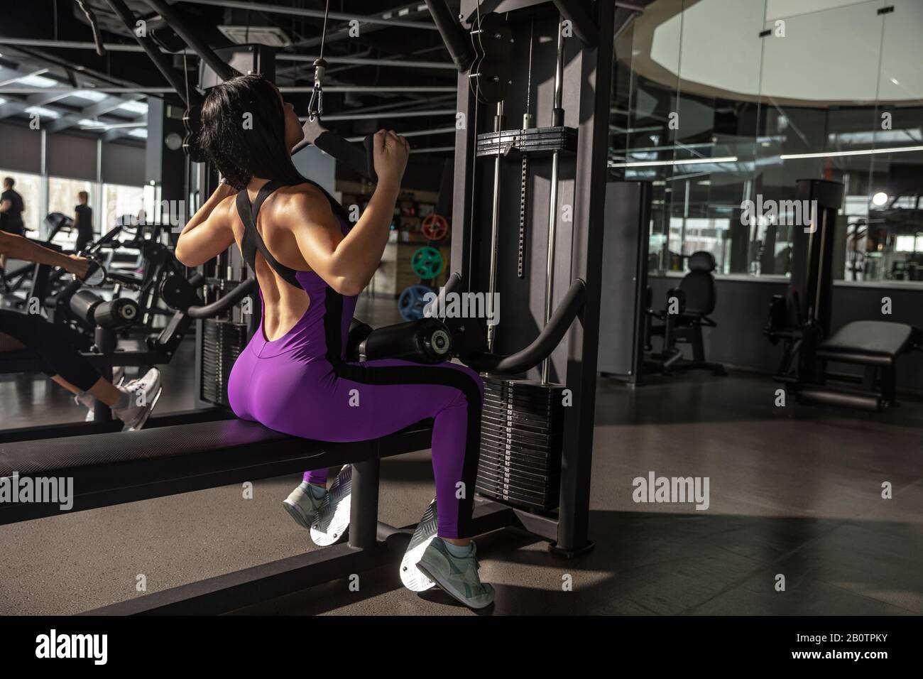 Strong. Young muscular caucasian woman practicing in gym with equipment ...