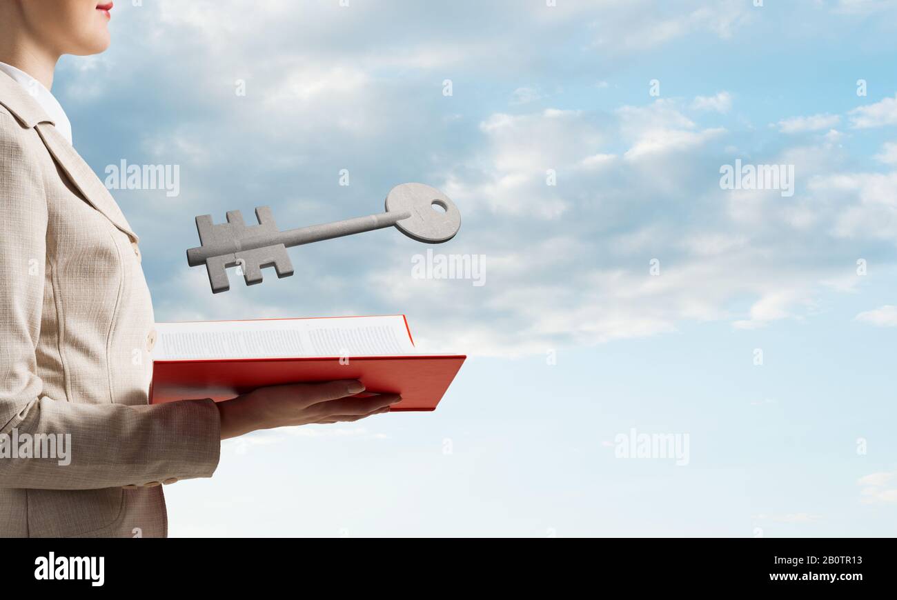 Woman showing big metal key Stock Photo - Alamy