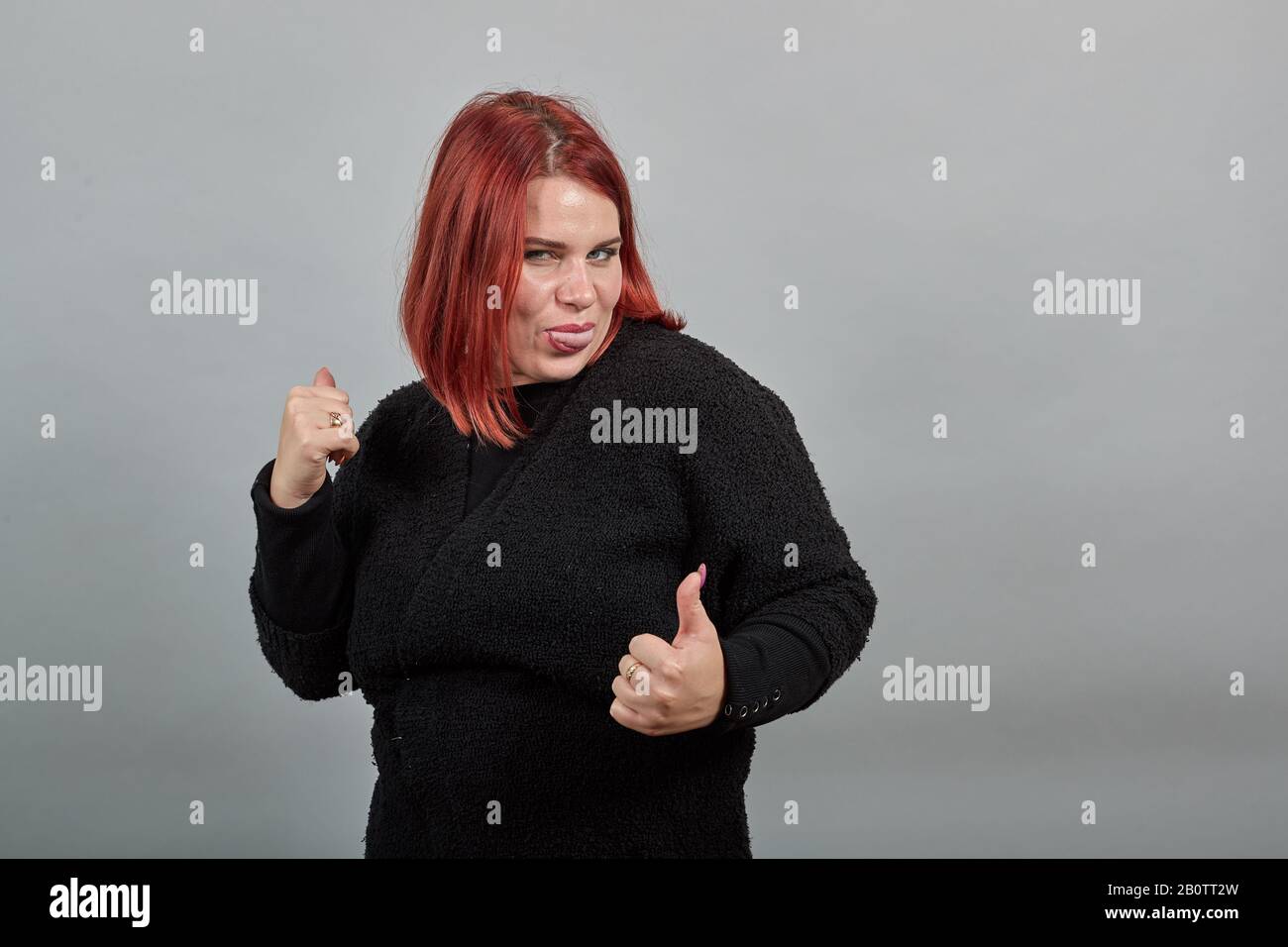 redhead fat lady in black sweater funny woman shows tongue and holds ...