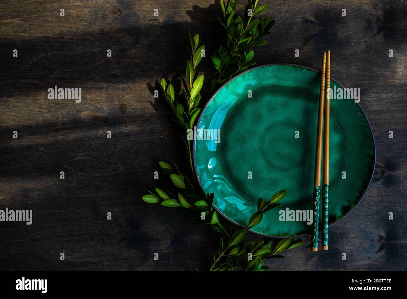 Asian style table setting with cherry blossom and wooden chopsticks ...