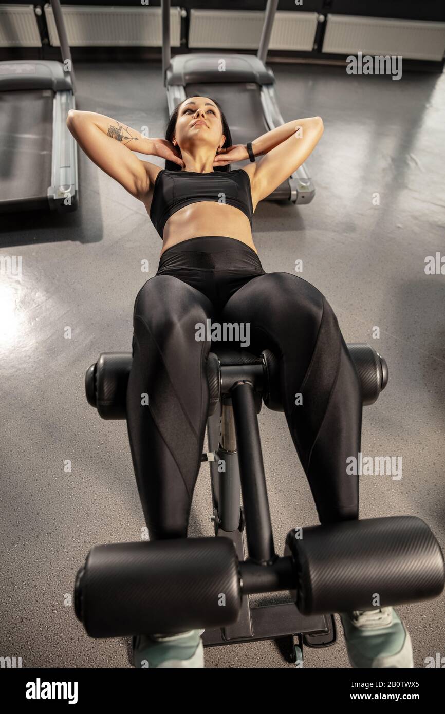 Wellness. Young muscular caucasian woman practicing in gym with ...