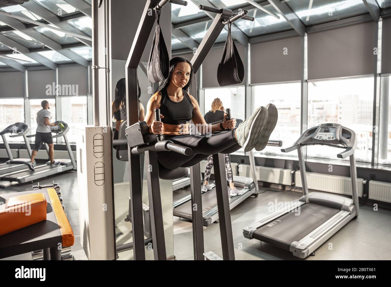 Wellness. Young muscular caucasian woman practicing in gym with ...
