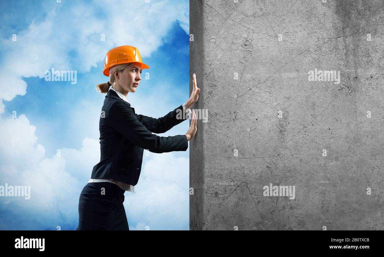 Beautiful woman architect pushing concrete wall Stock Photo - Alamy