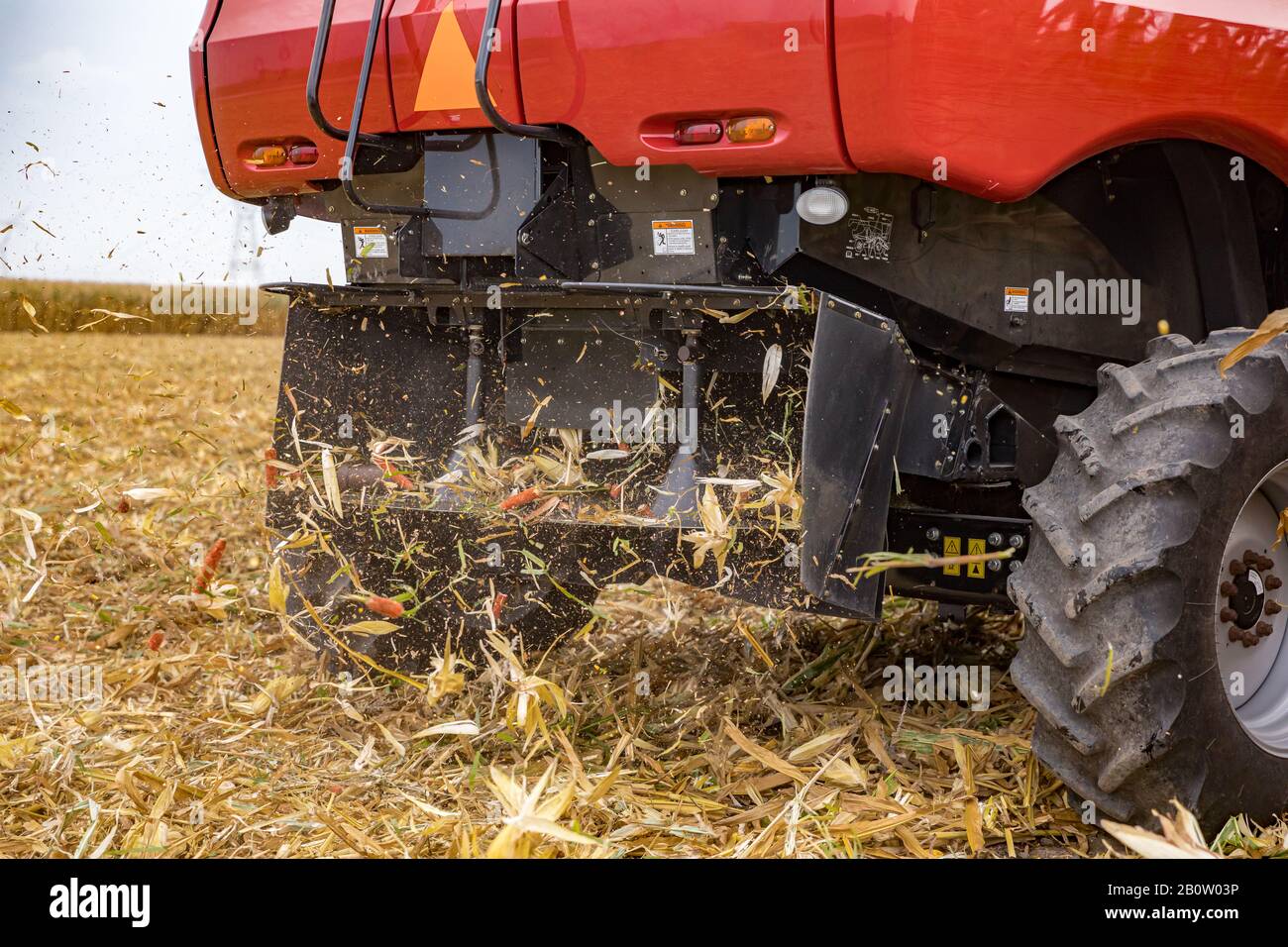 Closeup of chaff spreader on combine harvester harvesting cornfield ...