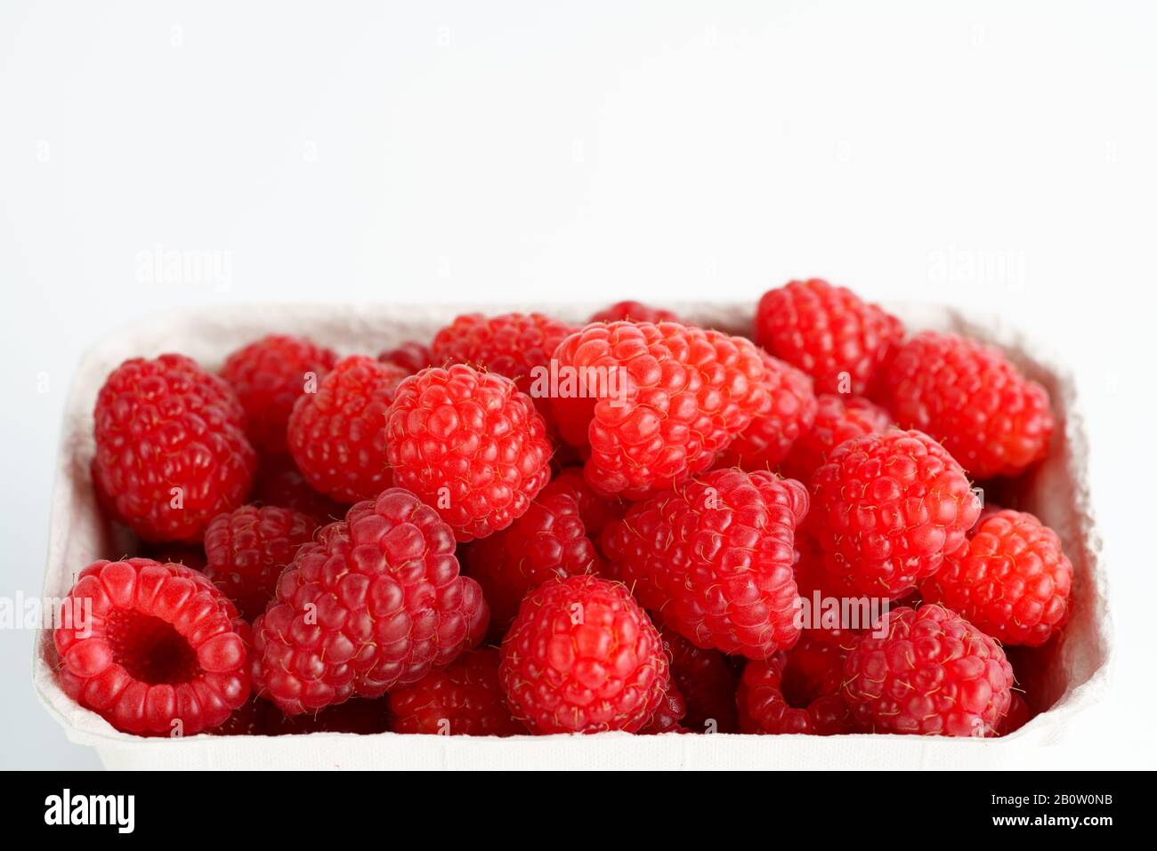 Freshly picked organic raspberries in recycled paper cup. High ...