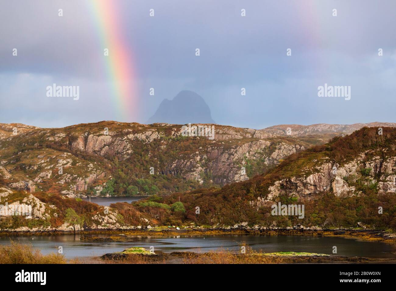 Rainbow in dark sky over Suilven mountain in remote Scottish Highlands ...