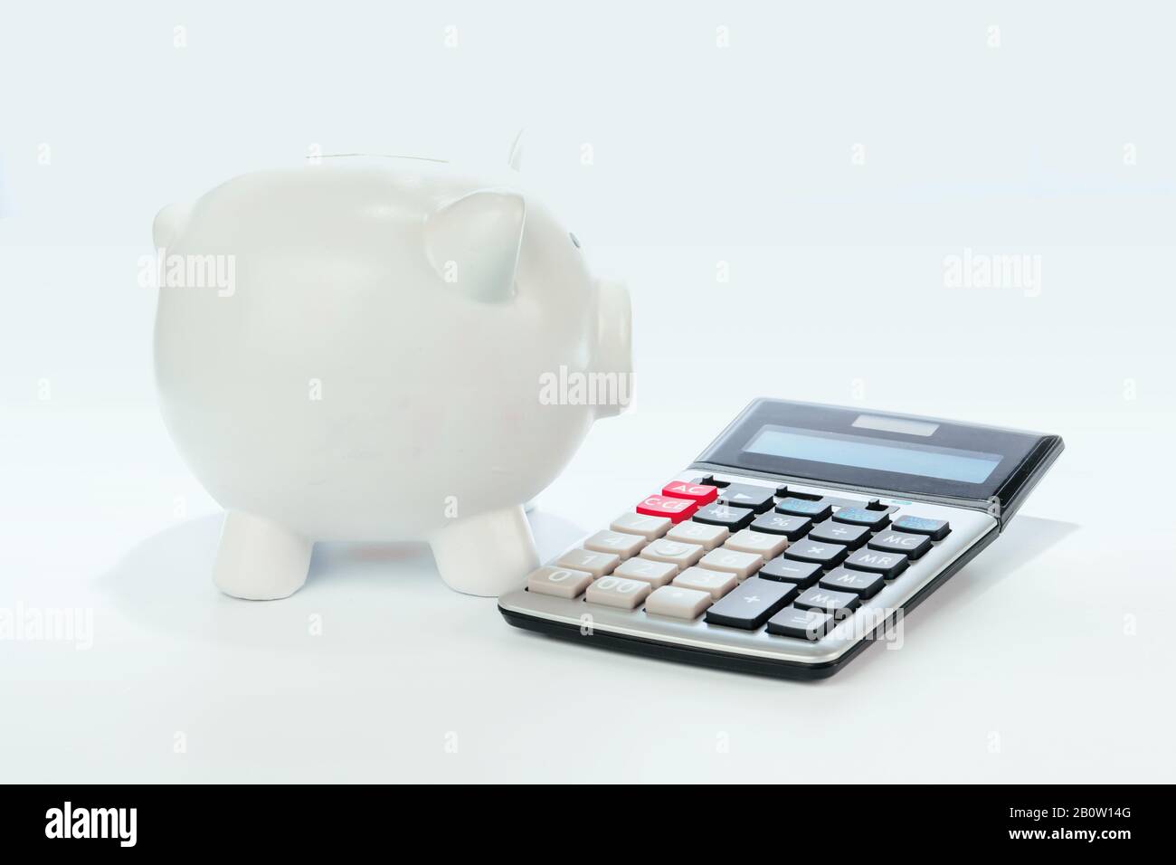 Piggy Bank with calculator on white background Stock Photo - Alamy
