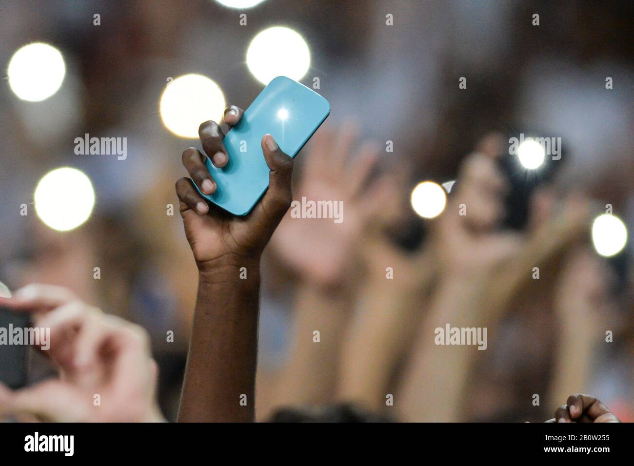 Person holding a cellphone with the flash on and hands up Stock Photo ...