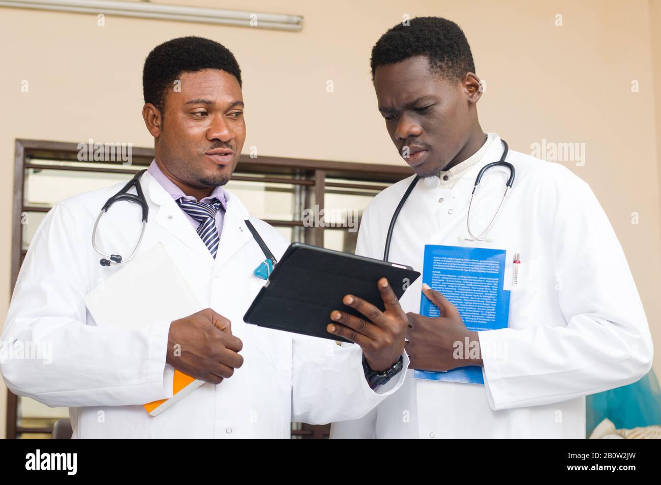 doctor and professor standing talking on a digital tablet at the ...