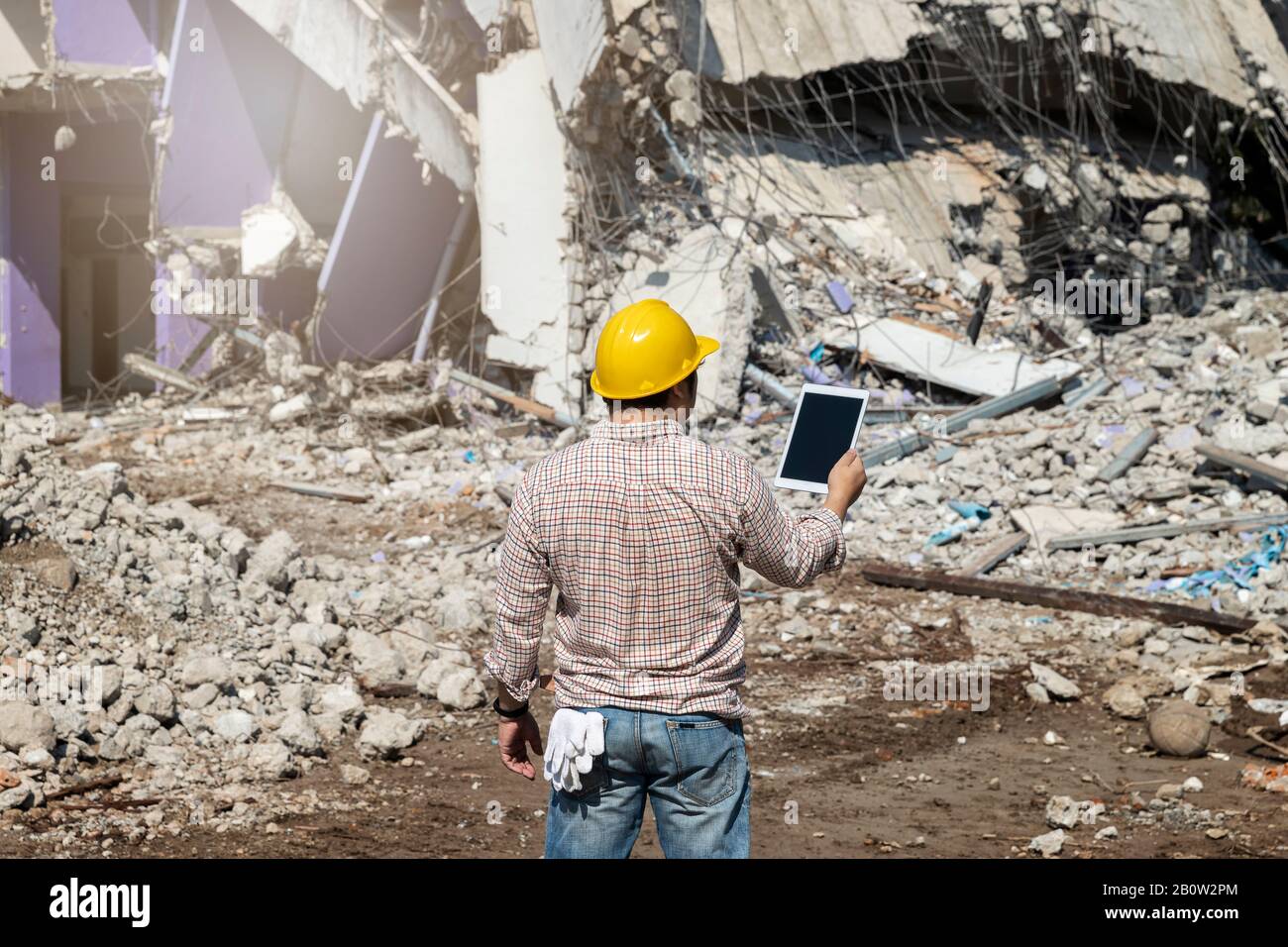 Engineer holding tablet is checking for destruction, demolishing ...