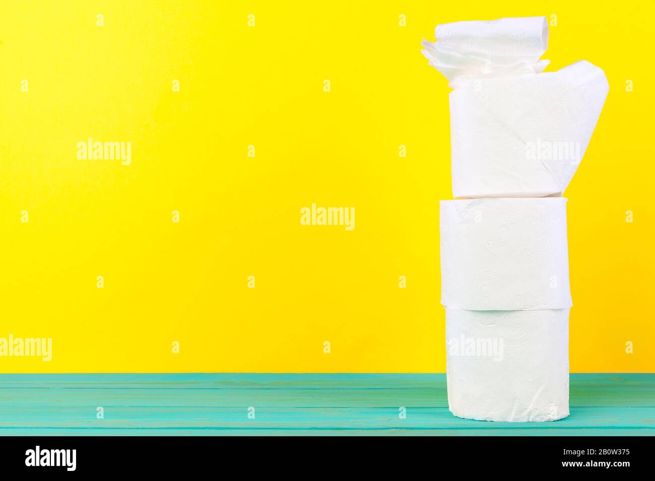 Toilet paper stacks on bright yellow background Stock Photo - Alamy