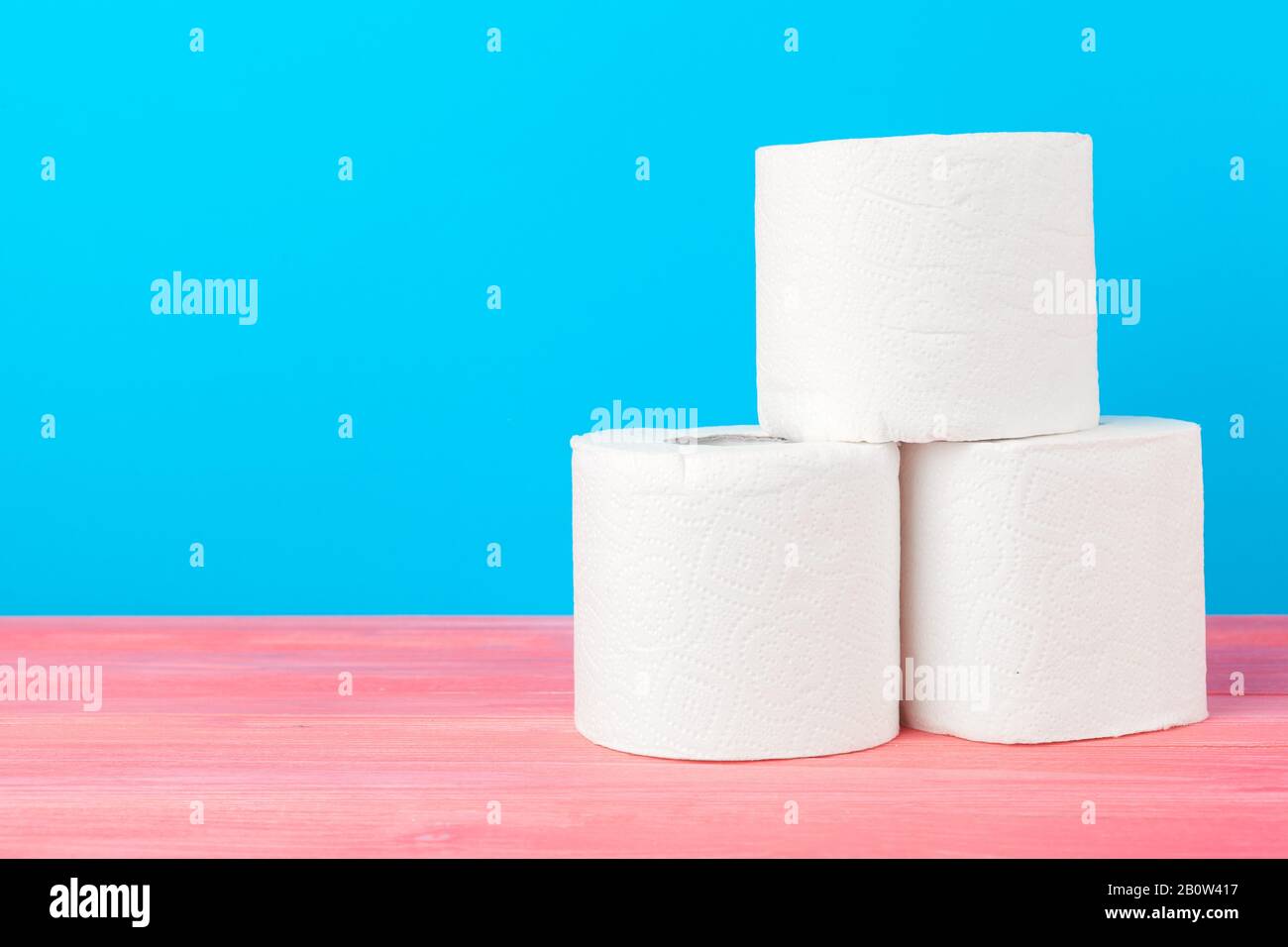 Toilet paper stack on bright blue background Stock Photo - Alamy