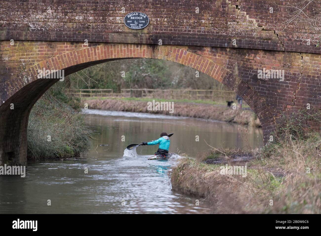 canoe person on river with back to camera going under bridge Stock ...