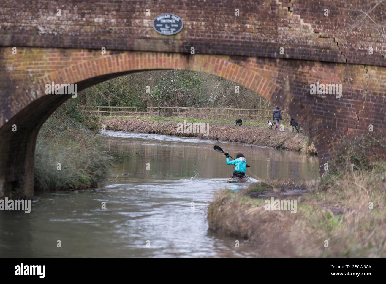 canoe person on river with back to camera going under bridge Stock ...