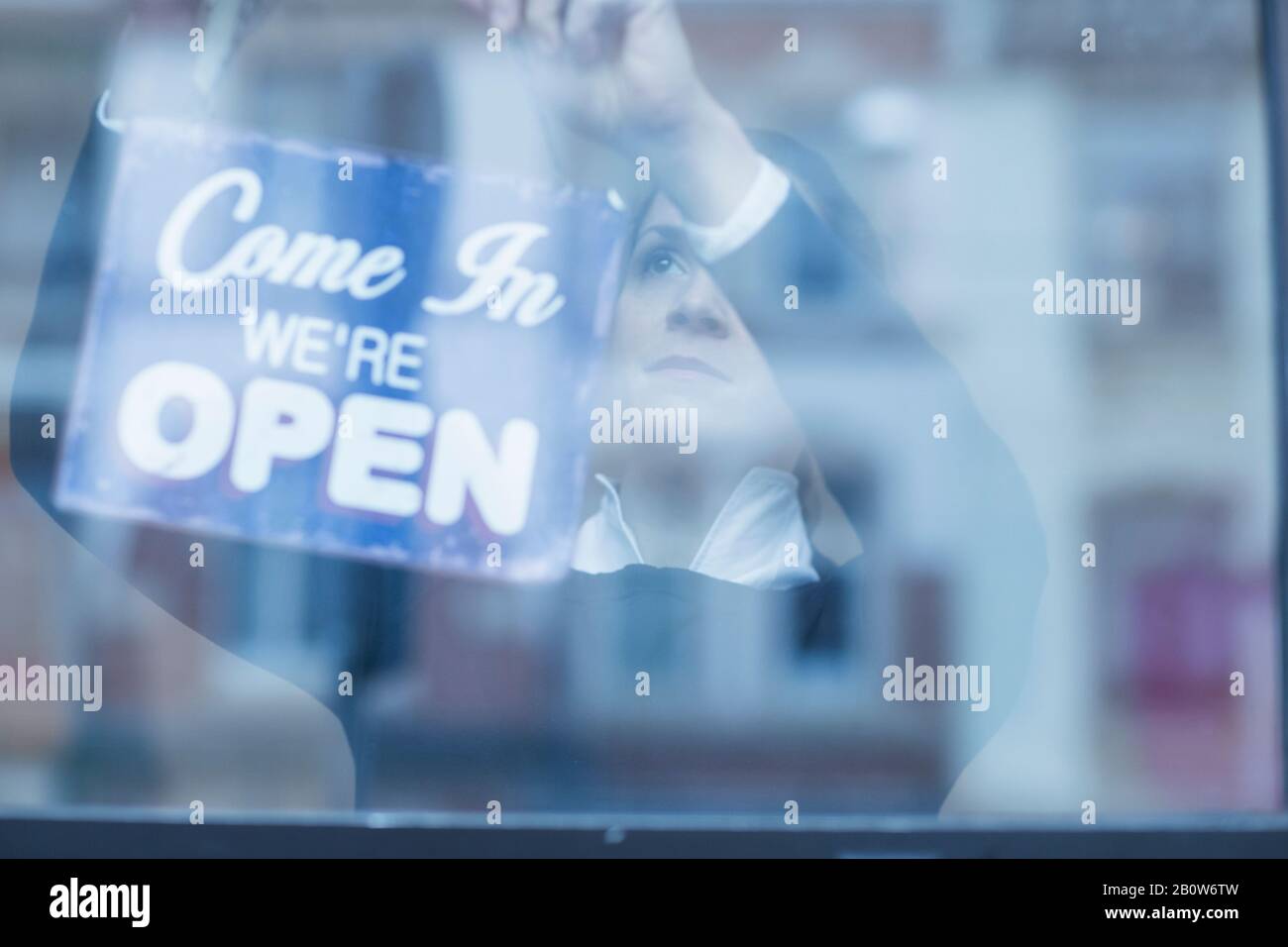 Women hanging open sign hi-res stock photography and images - Alamy