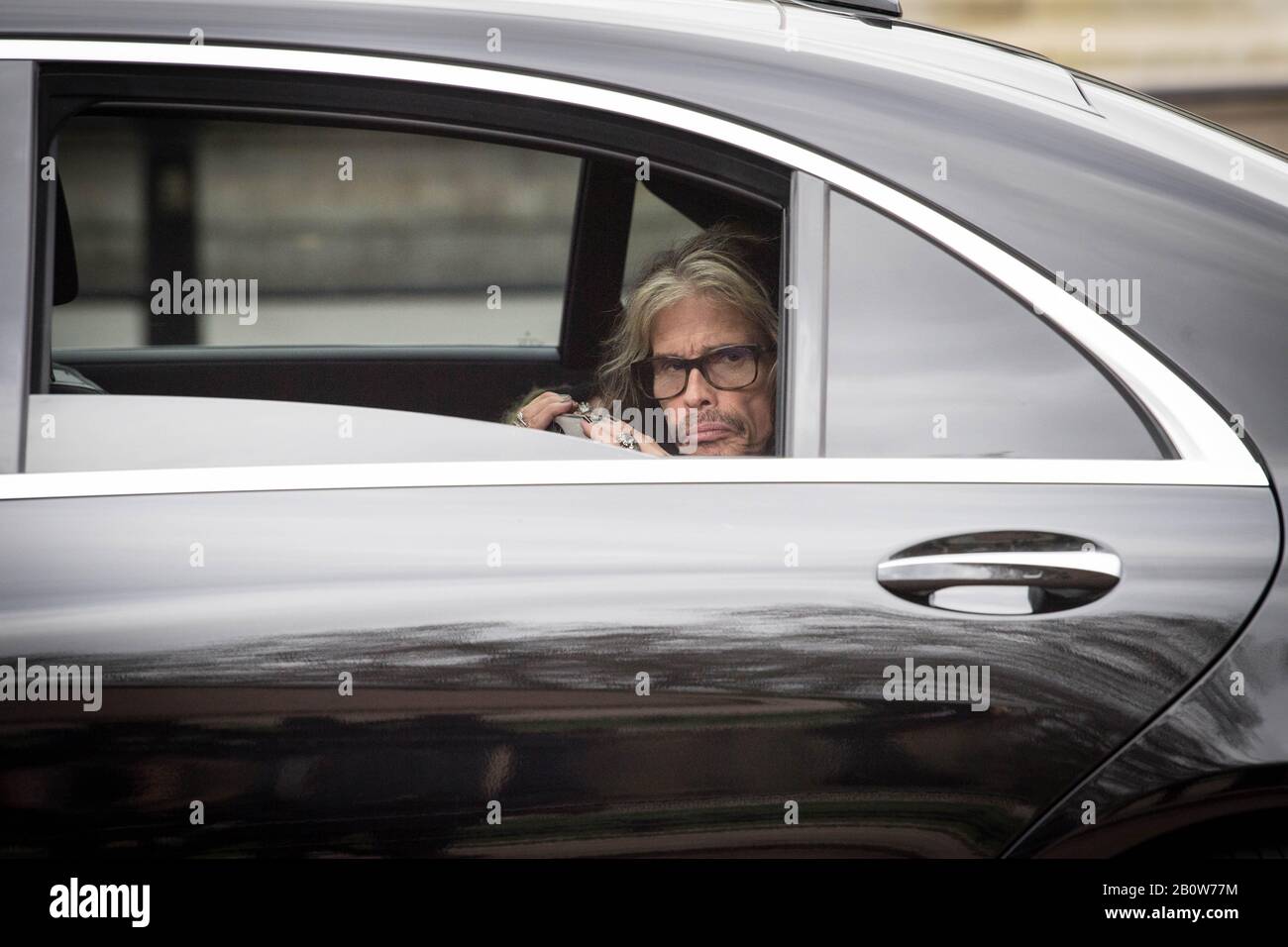 Steve Tyler, singer with the band Aerosmith peers out of a car window ...