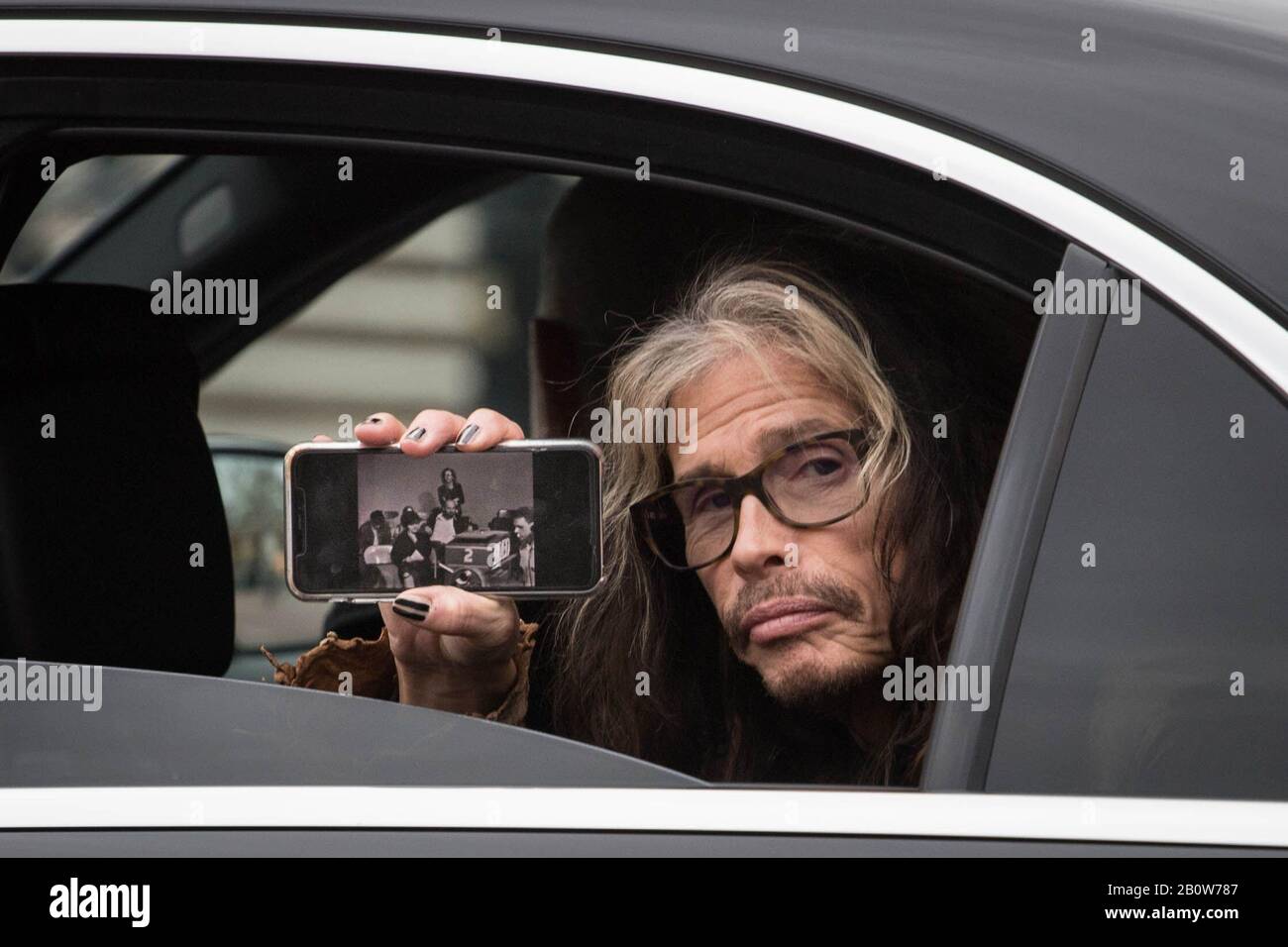 Steve Tyler, singer with the band Aerosmith peers out of a car window ...