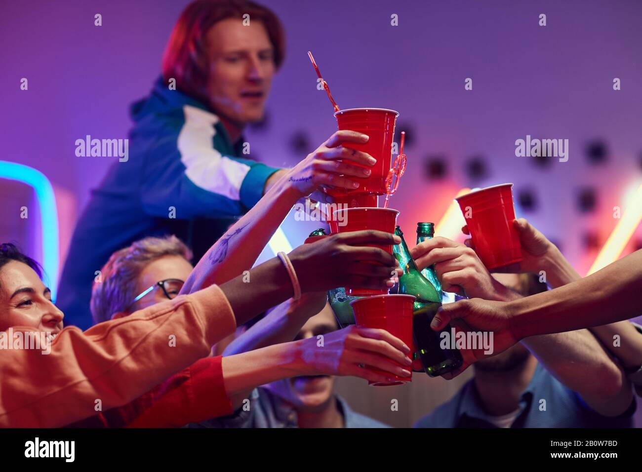 Close-up of group of young people holding red cups with beer and ...