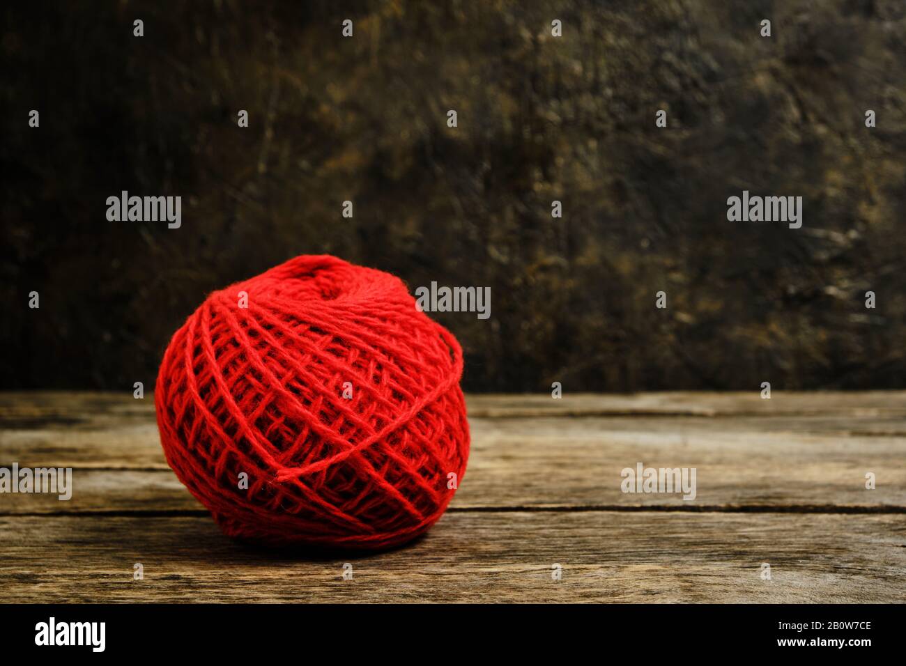 Red ball of wool yarn against an old wall Stock Photo - Alamy
