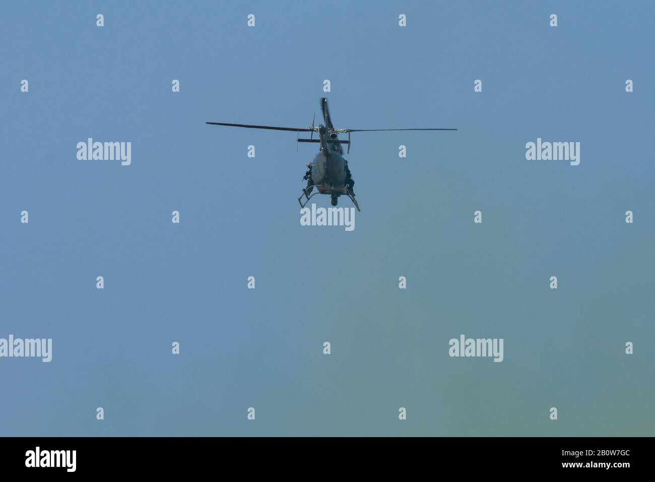 Military chopper flying away thorugh smoke in combat and war flying ...