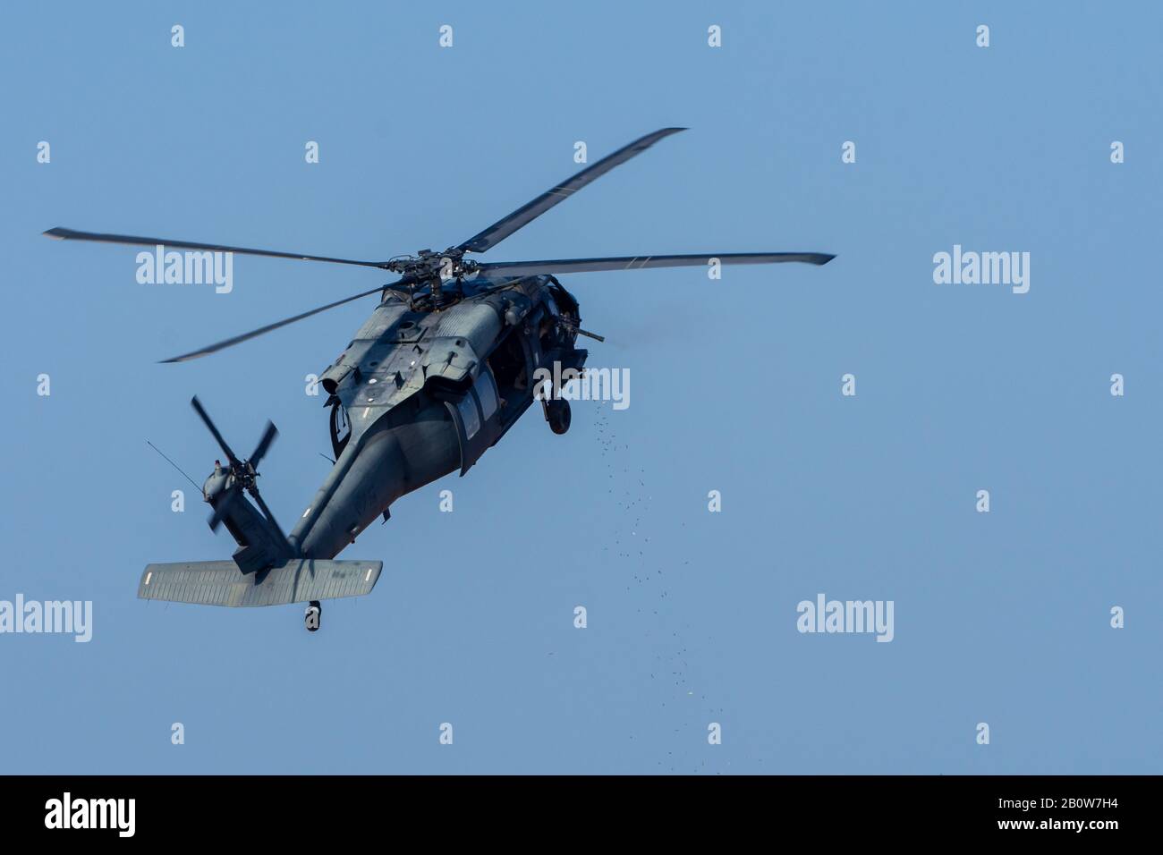 Military chopper shooting machine guns in combat and war flying into ...