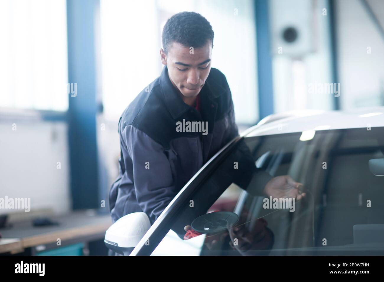 Workman fixing car windshield in workshop Stock Photo - Alamy