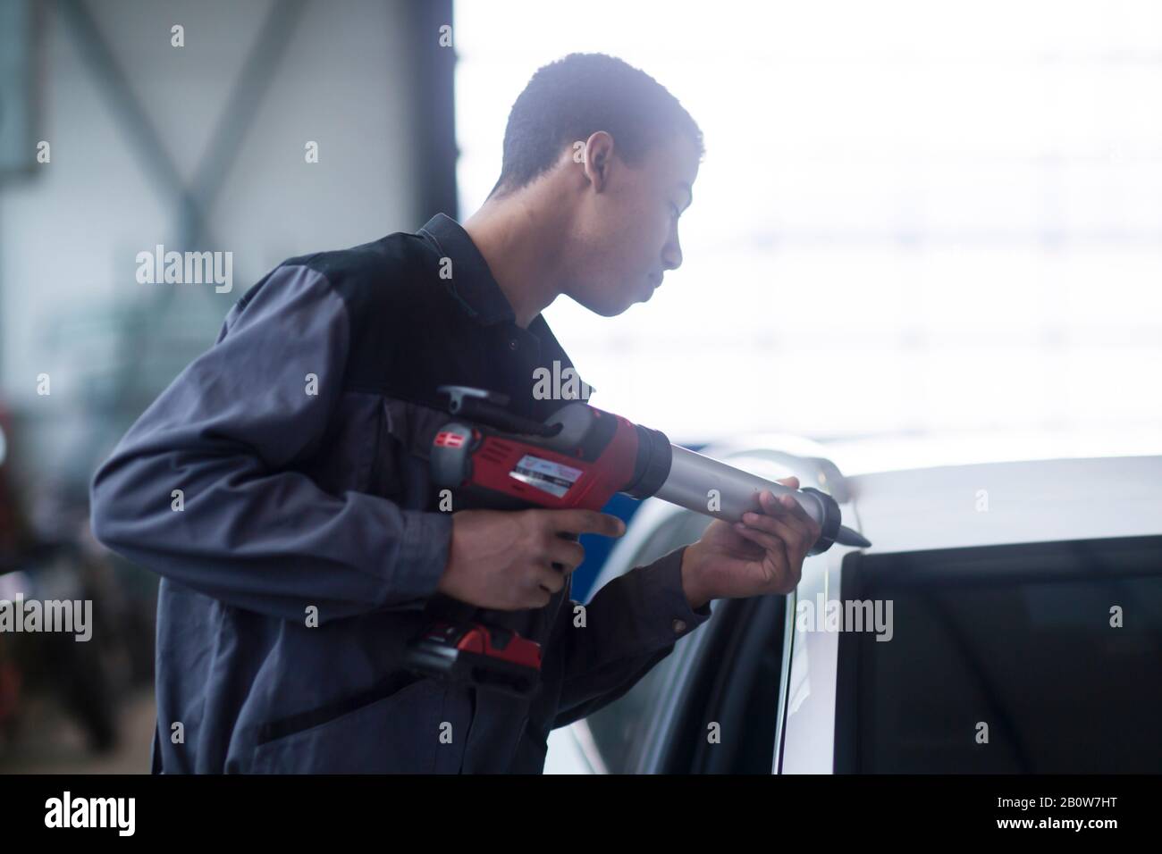 Workman fixing car windshield in workshop Stock Photo - Alamy