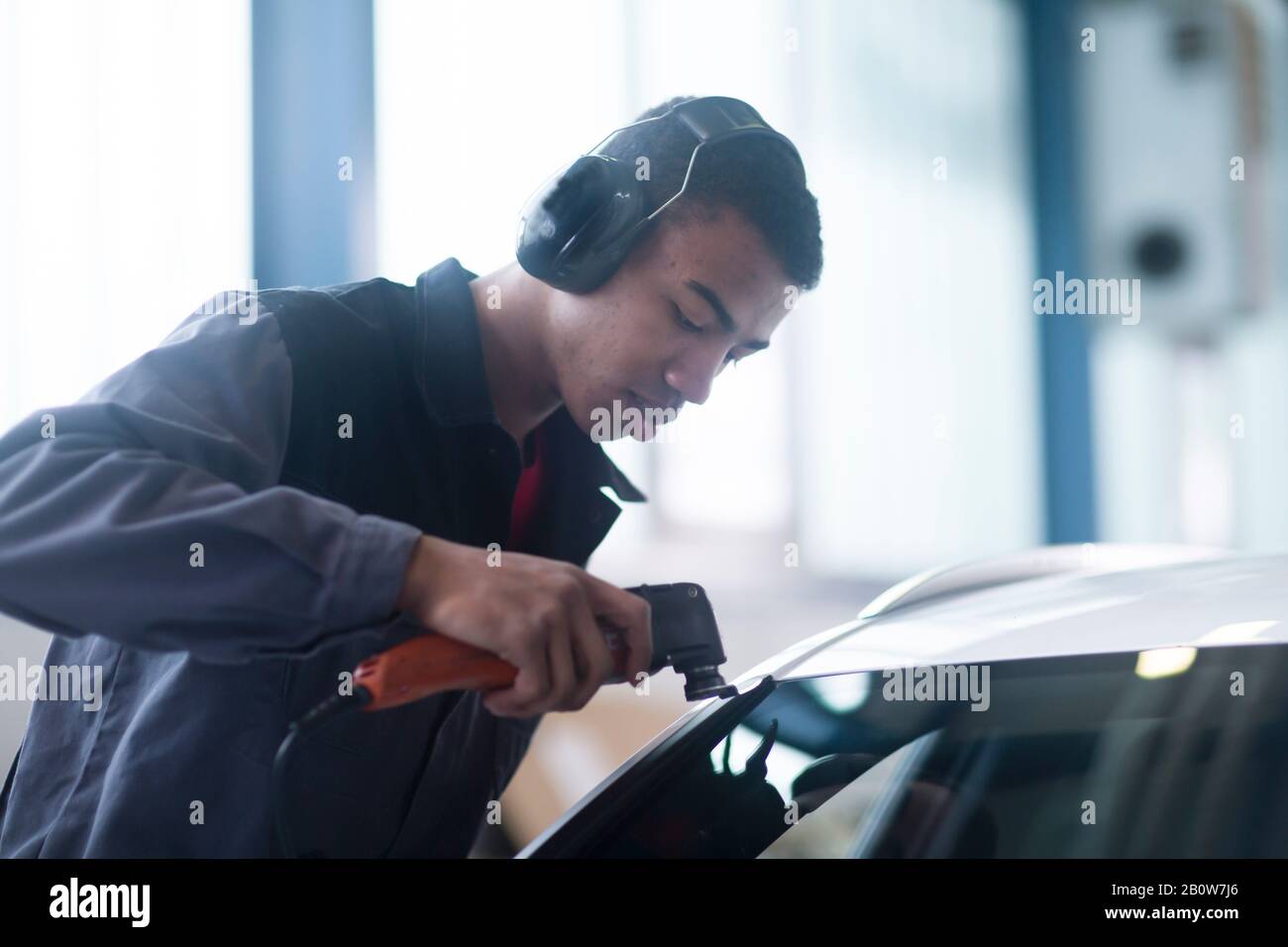 Workman fixing car windshield in workshop Stock Photo - Alamy