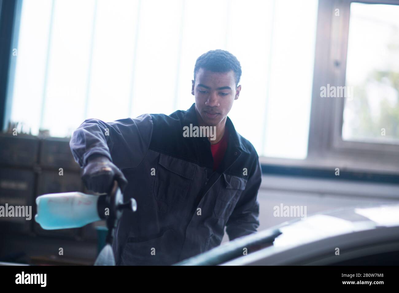 Workman fixing car windshield in workshop Stock Photo - Alamy