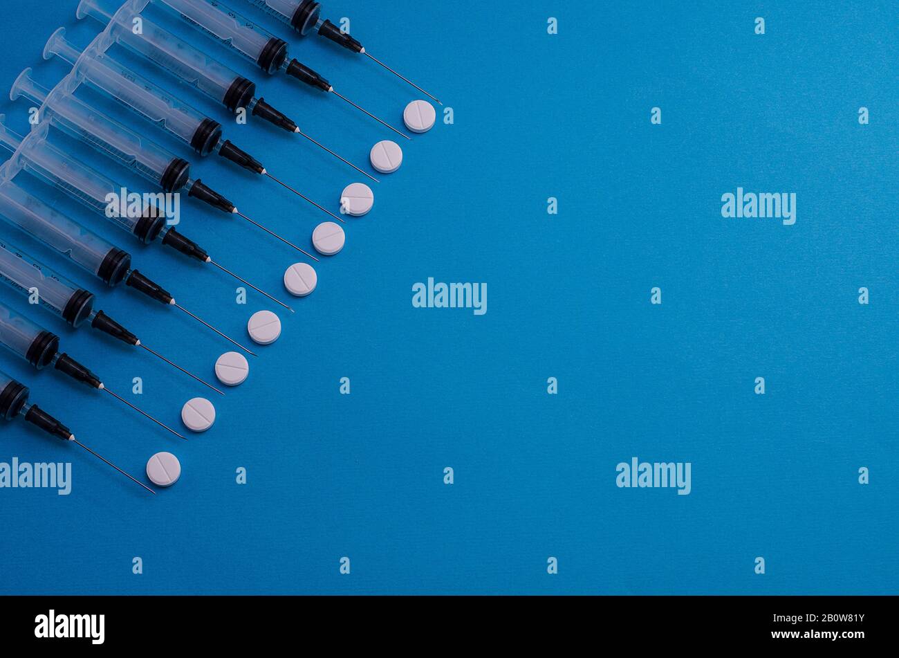 Pills and syringes on a light blue background with copy space ...