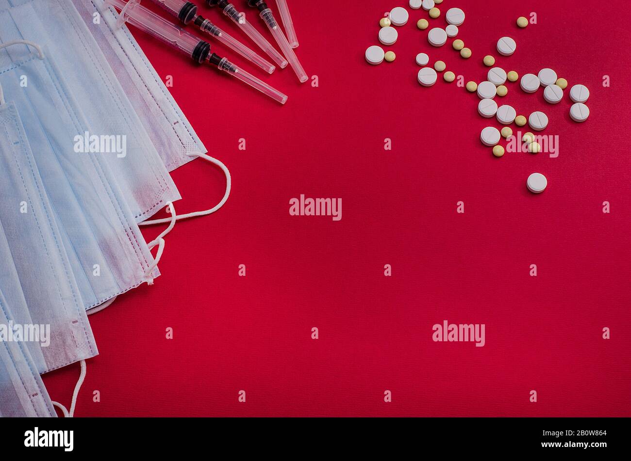 Pills, masks, syringes on a red background with copy space. The spread of coronavirus. Viral ...